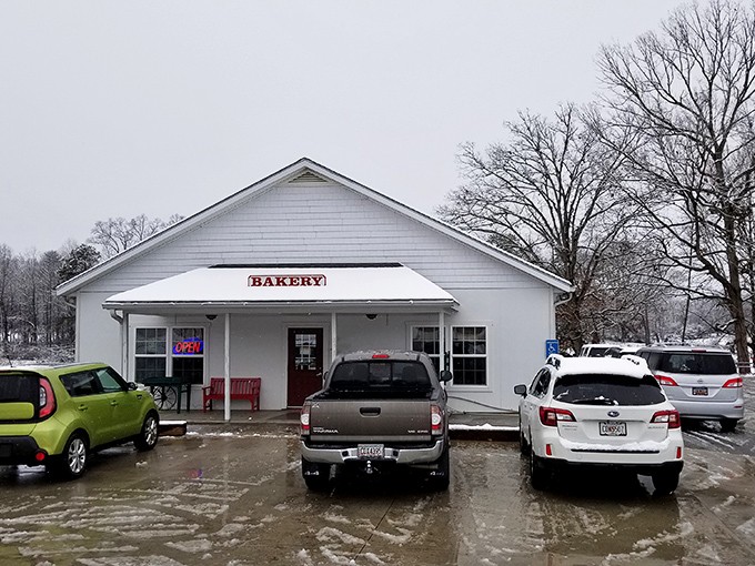 The quintessential country bakery facade&mdash;white clapboard, red accents, and a wooden wagon that silently promises carbs worth every mile of your journey.