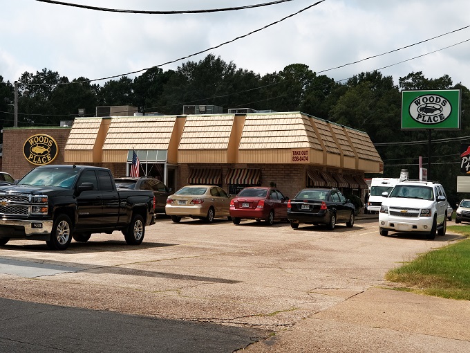 The unassuming exterior of Woods Place, with its distinctive green trim and simple sign, stands as Camden's culinary beacon for catfish aficionados.