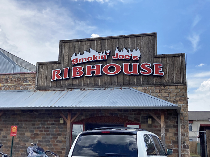 The red-roofed wooden exterior of Smokin' Joe's stands like a barbecue beacon in Rogers, promising smoky treasures within. A full parking lot never lies.