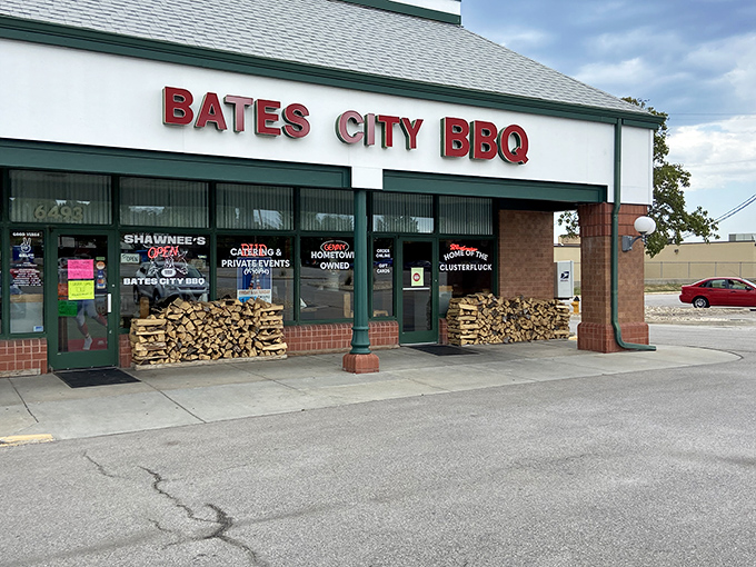 The unassuming storefront of Bates City BBQ, where stacked firewood isn't decor&mdash;it's a promise of smoky delights waiting inside.