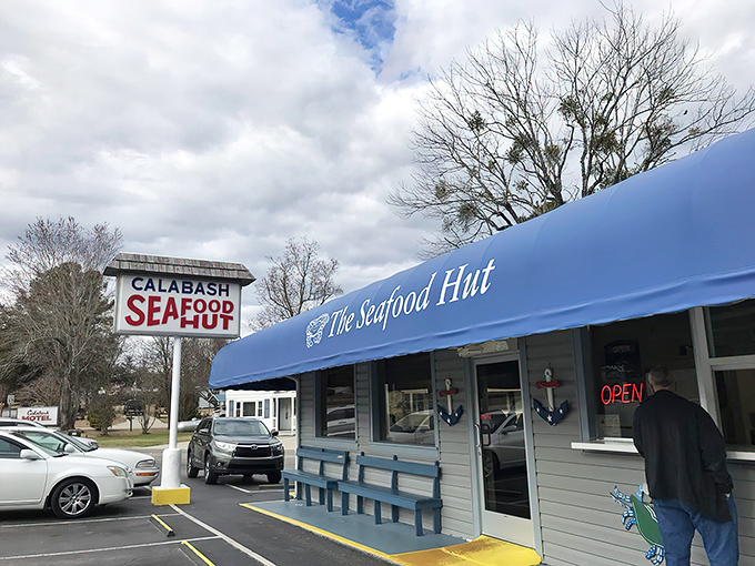 The iconic blue awning and simple sign of Calabash Seafood Hut stand as a beacon for seafood pilgrims. No fancy frills needed when the food speaks this loudly.
