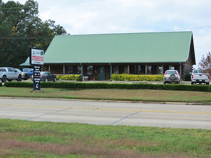 The rustic log cabin exterior of The Oaks isn't trying to impress you&mdash;until you taste what's cooking inside. Green roof, wooden benches, and promises of carnivorous delight await.