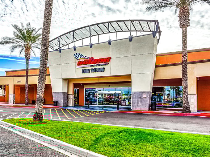 The entrance to Octane Raceway stands like a modern-day coliseum for speed demons, palm trees swaying as if applauding your imminent victory lap.