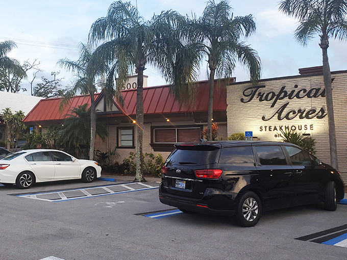 Tropical Acres stands like a time-honored oasis amid swaying palms, its iconic red roof and yellow walls promising culinary treasures within.