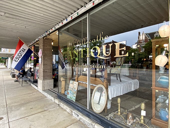 The storefront beckons like a time portal, with mid-century furniture artfully arranged behind glass and that glowing "Chillicothe ANTIQUE" sign promising adventures in nostalgia.