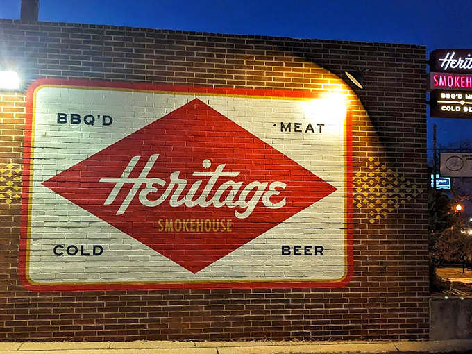The red diamond logo glows like a beacon in the night, promising the holy trinity of BBQ: meat, smoke, and cold beer.