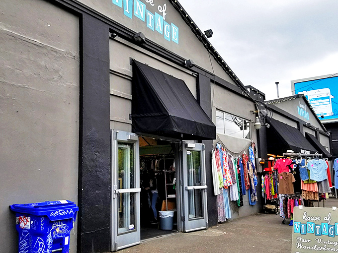 The unassuming storefront of House of Vintage beckons with colorful clothing racks outside, like a portal to decades past waiting to be explored.
