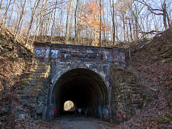 Nature reclaims what man abandoned at Moonville Tunnel, where vibrant greenery frames this portal to the past. The perfect backdrop for both daytime adventures and nighttime frights.