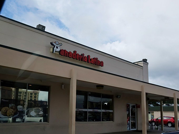 The bright red signage of Panaderia Latina beckons like a beacon of culinary promise. Coffee, cakes, and pastries await behind those unassuming doors.