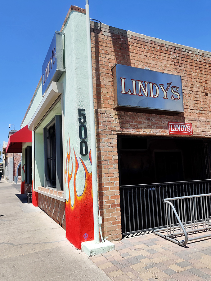 The unassuming brick exterior of Lindy's on 4th, complete with flame accents, stands as Tucson's temple to burger excess. Greatness often hides in plain sight.
