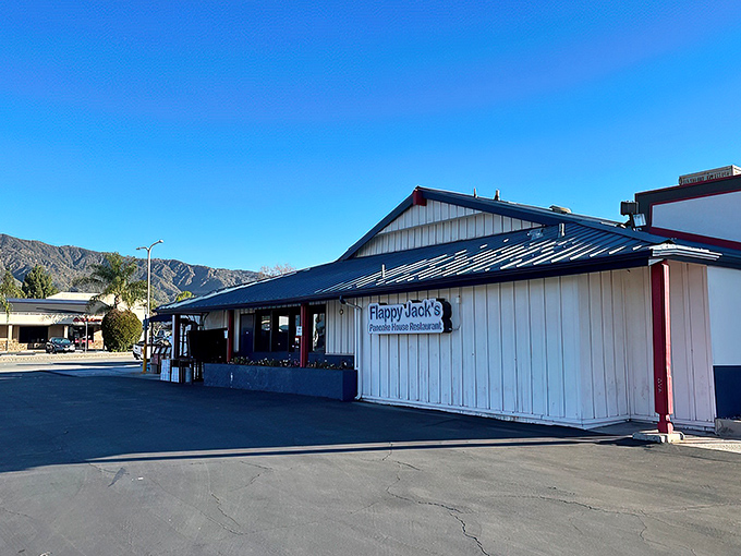 The blue-roofed sanctuary of breakfast dreams awaits on Route 66, where hungry pilgrims find solace in sizzling skillets and coffee refills. 
