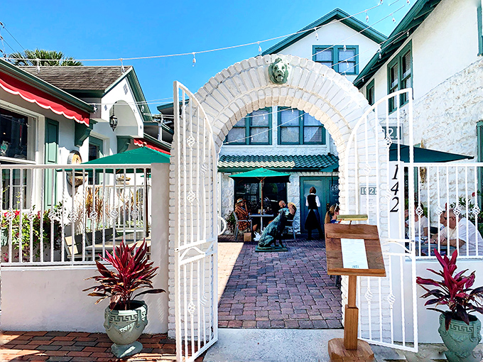 A welcoming white archway leads to culinary paradise, where even the dog statue seems to be saying, "Trust me, you're going to love this place."