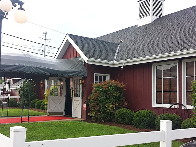 The iconic red barn exterior of Aberdeen Barn stands proudly on Holiday Drive, welcoming hungry patrons with its charming white picket fence and unmistakable rustic appeal.