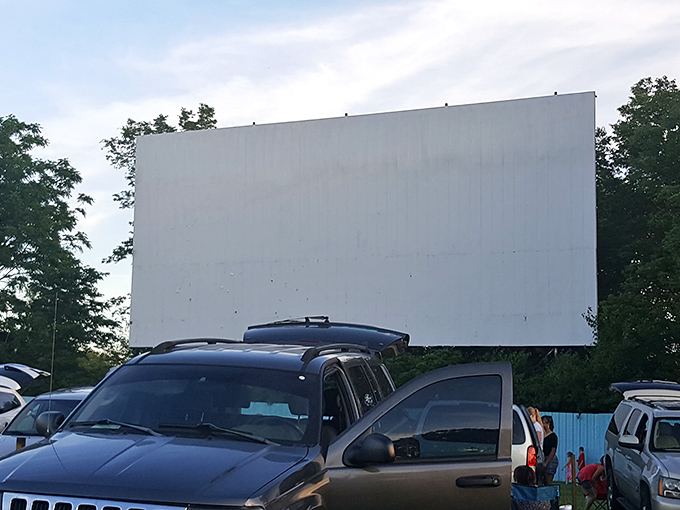 Cars lined up under the open sky, where the humble drive-in transforms ordinary evenings into cinematic adventures. Pure Americana at its finest.