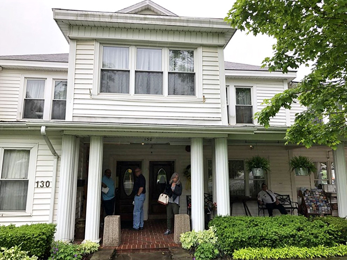 The white clapboard exterior with its American flag and welcoming porch feels like stepping into a Norman Rockwell painting of Southern hospitality.
