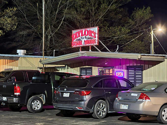 The unassuming exterior of Taylor's Steakhouse stands like a carnivore's lighthouse in Dumas, its iconic red sign promising meaty treasures within.