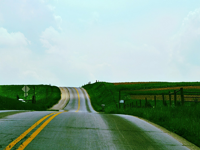 The open road stretches before you like nature's welcome mat, with clouds performing their own version of Cirque du Soleil overhead.