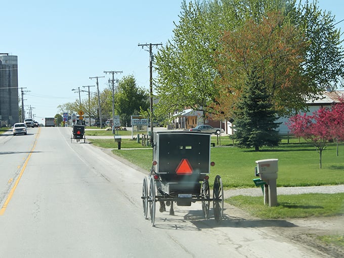 Where time travels at eight miles per hour. Amish buggies with their iconic orange safety triangles share the road with modern vehicles in Shipshewana. 