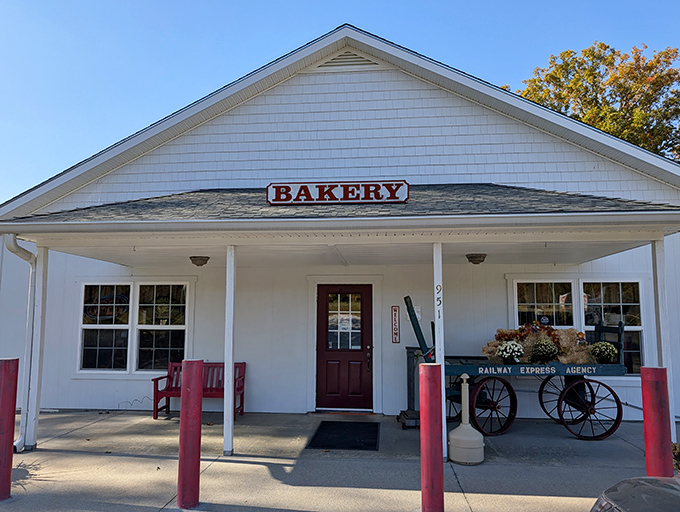 The quintessential country bakery facade&mdash;white clapboard, red accents, and a wooden wagon that silently promises carbs worth every mile of your journey.