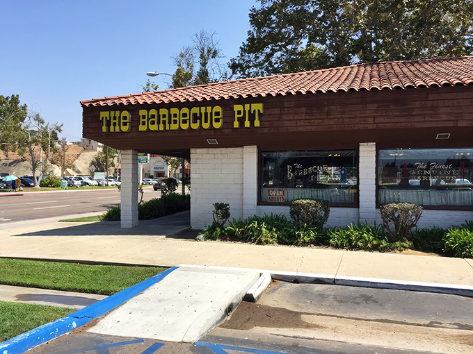 The unassuming exterior of The Barbecue Pit stands like a beacon of hope for hungry travelers. That yellow sign promises smoky salvation within those humble walls.