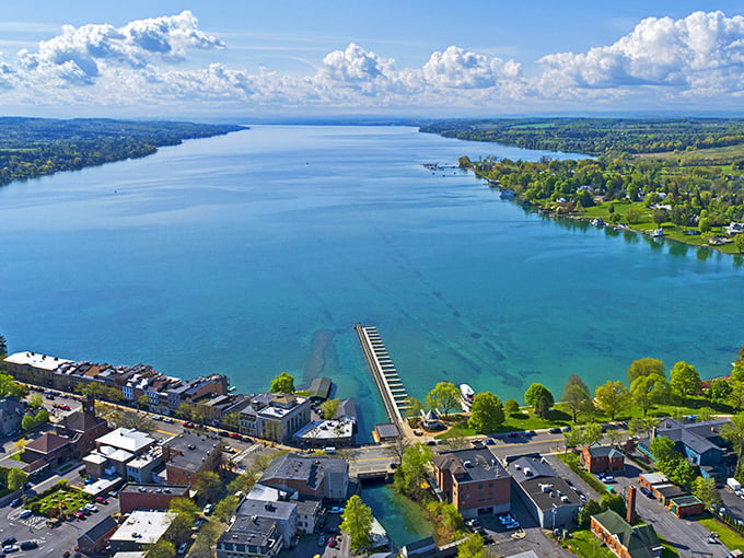 Skaneateles Lake stretches like nature's runway, its pristine blue waters flanked by emerald shorelines that promise relaxation and waterfront dining adventures.