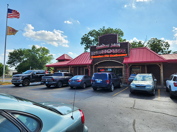The red-roofed wooden exterior of Smokin' Joe's stands like a barbecue beacon in Rogers, promising smoky treasures within. A full parking lot never lies.