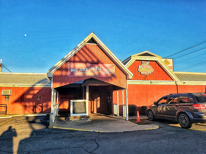 The iconic red barn exterior of Brangus Steakhouse stands out against the Arkansas sky like a beacon for hungry travelers seeking serious steak satisfaction.