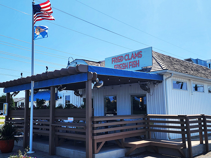 The classic white clapboard exterior with bold signage promising "FRIED CLAMS" and "FRESH FISH" is like a siren song to seafood lovers cruising coastal Delaware.