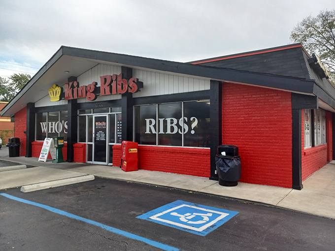 The bold red-and-black exterior announces its mission without pretense: "WHO'S RIBS?" Not a question, friends&mdash;a declaration of barbecue sovereignty.