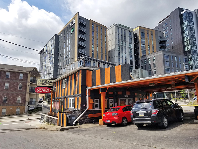 The iconic orange and black striped exterior of Triple XXX stands like a time capsule on the hill, beckoning hungry travelers with its vintage Coca-Cola signage and timeless charm.