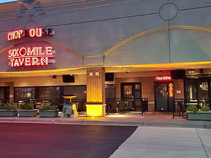 The neon sign of Six Mile Chop House beckons like a carnivore's lighthouse, promising safe harbor for the steak-obsessed traveler in Lawrence.