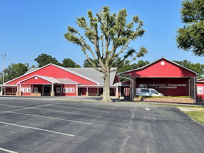 The iconic red barn exterior of Homestead Steakhouse stands proudly against Carolina blue skies, promising carnivorous delights within its unassuming walls.