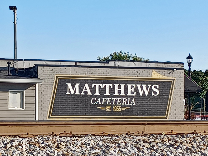 The classic striped awning of Matthews Cafeteria stands like a beacon of comfort food, promising Southern delights within these unassuming walls. 