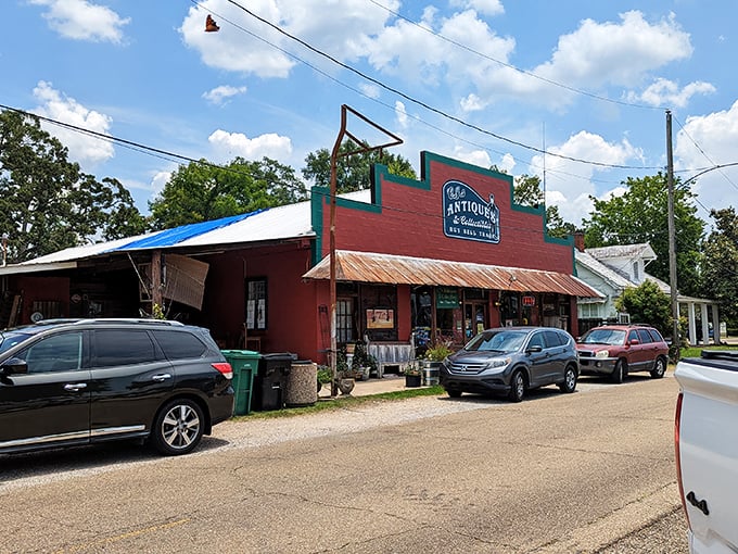 The vibrant red facade of C.J.'s Antiques & Collectibles stands out like a beacon for treasure hunters, promising adventures in nostalgia beneath that rustic metal roof.