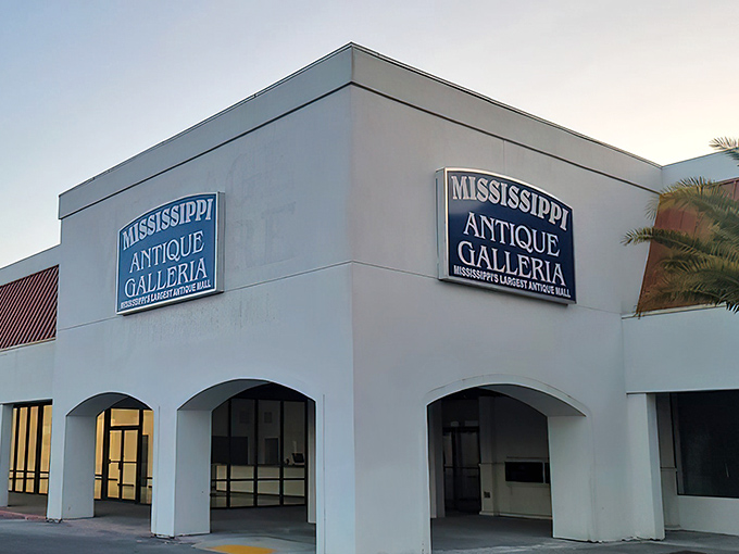 The classic car parked outside isn't just decoration—it's a time machine preview of the wonders waiting inside Mississippi Antique Galleria.