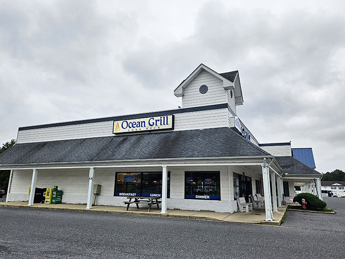 The white clapboard exterior of Ocean Grill stands like a beacon of comfort food promise. Those nautical round windows aren't just for show&mdash;they're portals to flavor town.