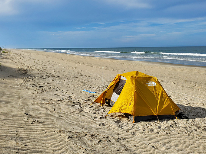 A bright yellow tent stands alone on miles of pristine shoreline. Social distancing at its most glorious natural extreme.
