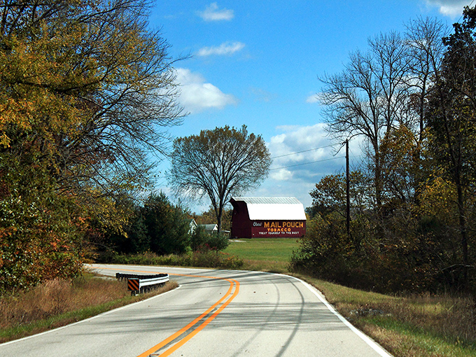 Nature's corridor awaits as autumn begins its slow dance along Highway 62. The limestone walls stand sentinel while trees prepare their grand finale.