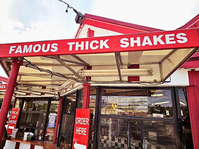 The iconic red and white striped exterior of Iceberg Drive Inn stands like a time capsule on 3900 South, promising nostalgic delights within.