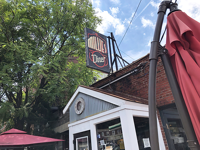 The unassuming brick exterior of Millie's Diner belies the culinary magic happening inside. That colorful mural isn't just decoration&mdash;it's a preview of the vibrant flavors awaiting you.