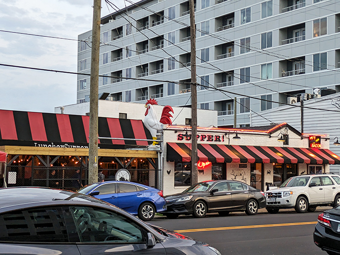 The iconic white brick exterior of LUNCH.SUPPER! with its jaunty red and black awning promises Southern comfort before you even step inside.