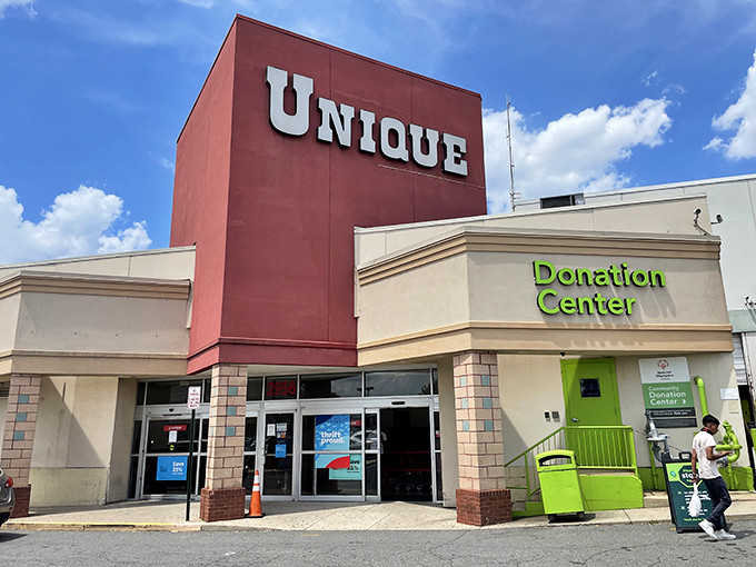 The iconic red facade of Unique Thrift Store stands like a beacon of bargain possibilities in Falls Church, promising treasures within those sliding glass doors.