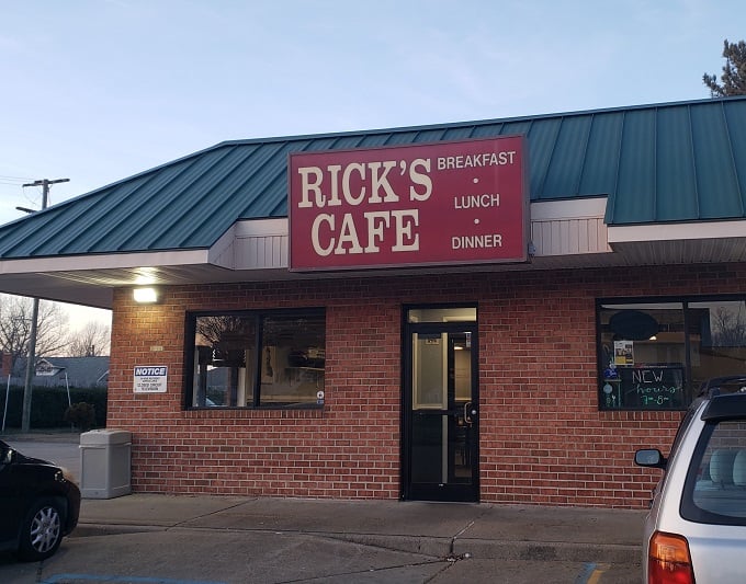 Welcome to Rick's Cafe, where the green roof and red sign beckon like a lighthouse for hungry souls. This unassuming exterior hides a treasure trove of comfort food delights!