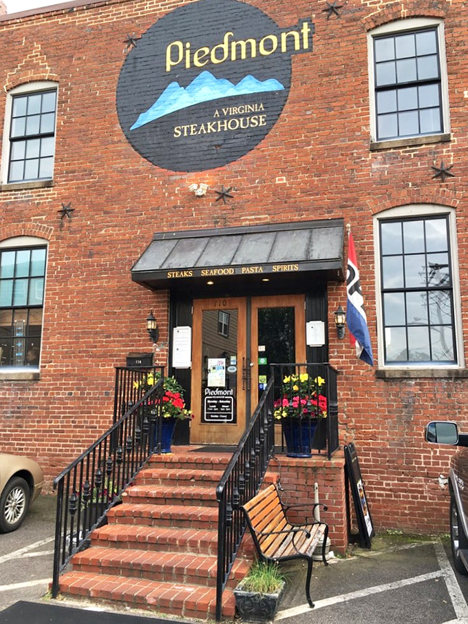 The historic brick facade of Piedmont Steakhouse welcomes you with understated elegance. Those bright blue planters aren't just decoration—they're your first hint that something special awaits inside.