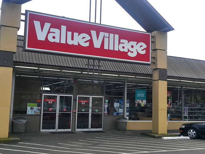 The iconic red Value Village sign beckons like a lighthouse for treasure hunters navigating the sea of suburban retail. Welcome to thrift paradise!