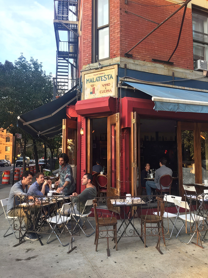 The corner where pasta dreams come true. Malatesta's weathered sign and rustic wooden windows promise authentic Italian comfort without pretension.