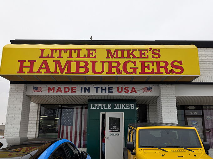 The bright yellow sign beckons like a burger lighthouse on the Oklahoma horizon. Nothing says "American classic" quite like that patriotic banner.