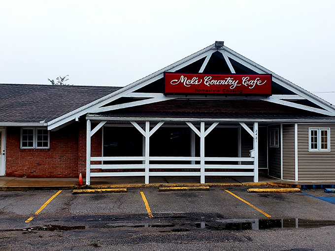 The unassuming exterior of Mel's Country Cafe sits like a red-signed promise of comfort food bliss under Missouri skies. 