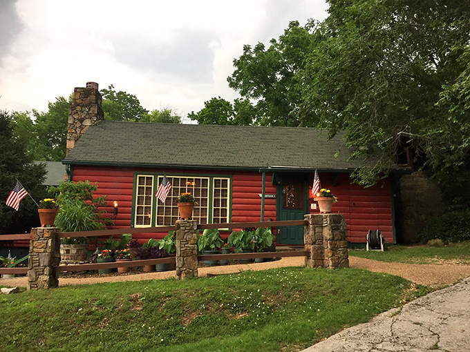 The red log cabin exterior with lush tropical plants says "frontier meets fine dining" before you even step inside.