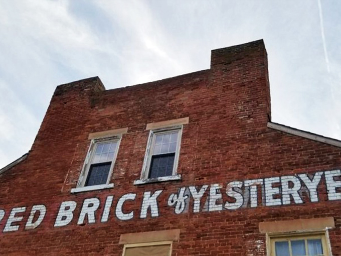 The historic facade of Red Brick Tavern stands proudly along Route 40, its weathered bricks whispering stories from nearly two centuries of serving hungry travelers.
